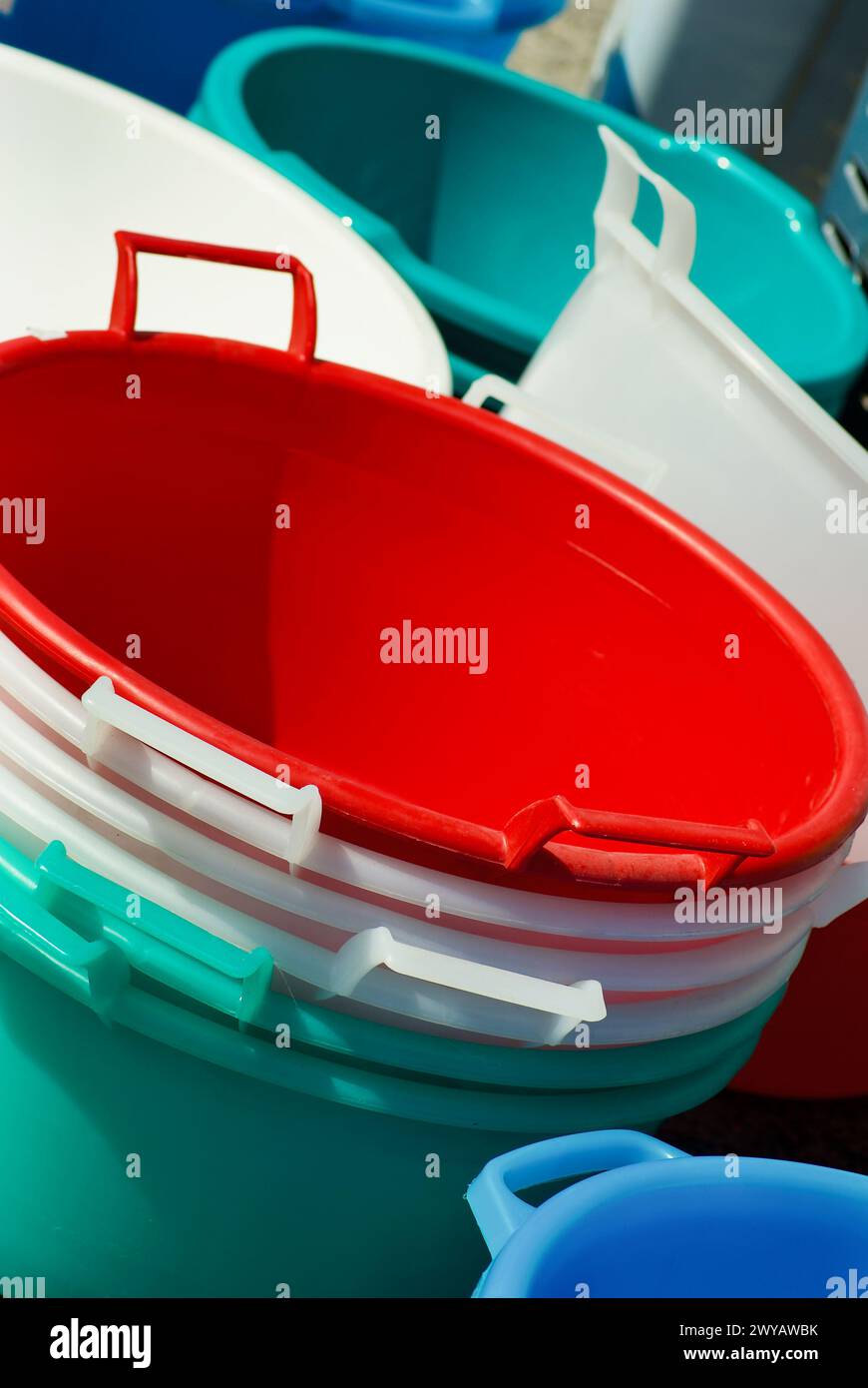 Many stacked plastic tubs in different colors for washing, storage ...