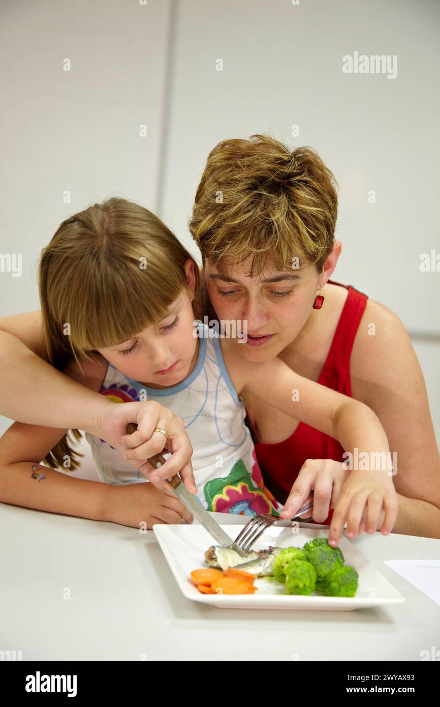 Mother and daughter eating vegetables, tasting session in sensory ...
