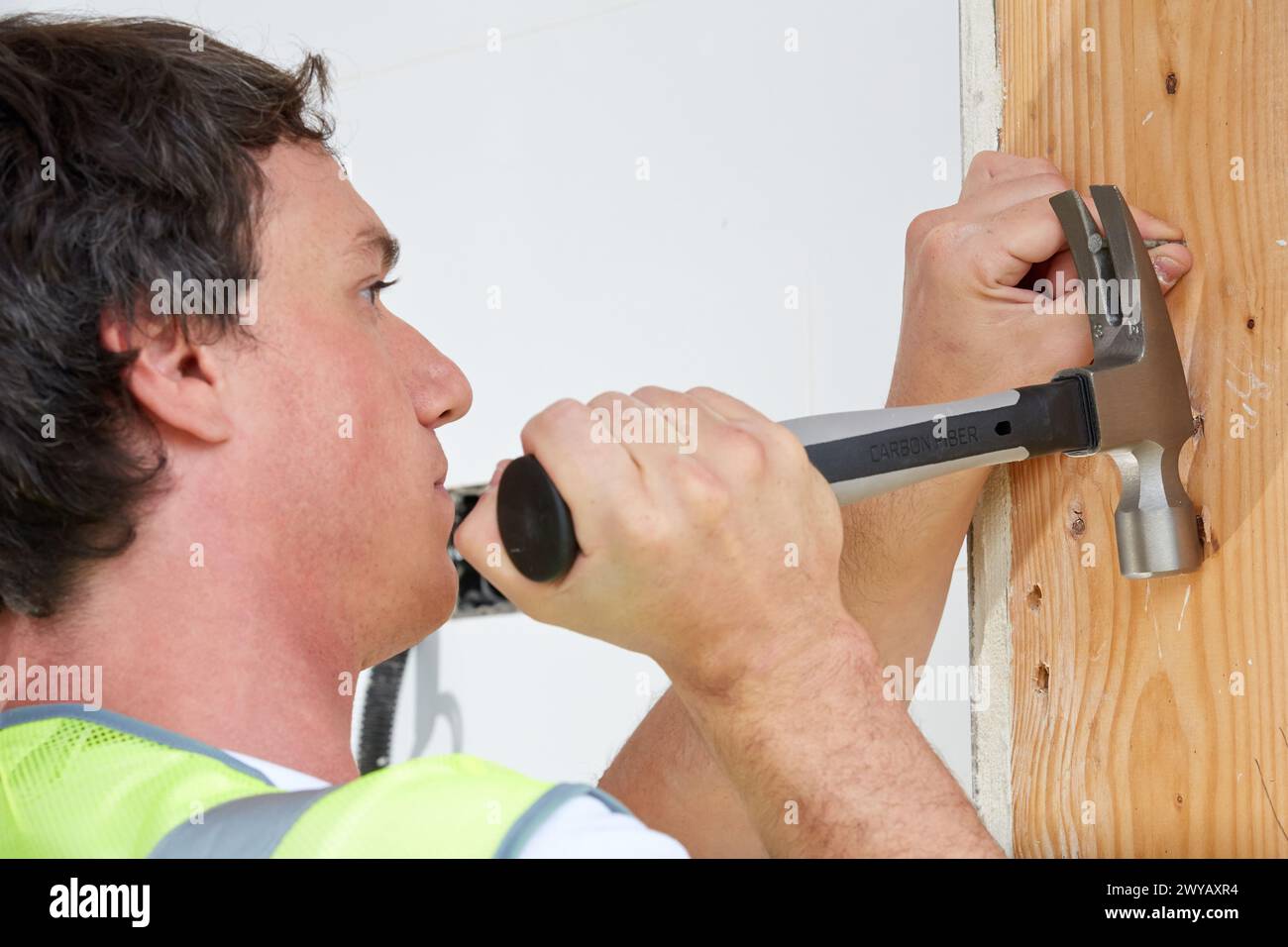 Carpenter with hammer with carbon fiber handle. Construction of ...