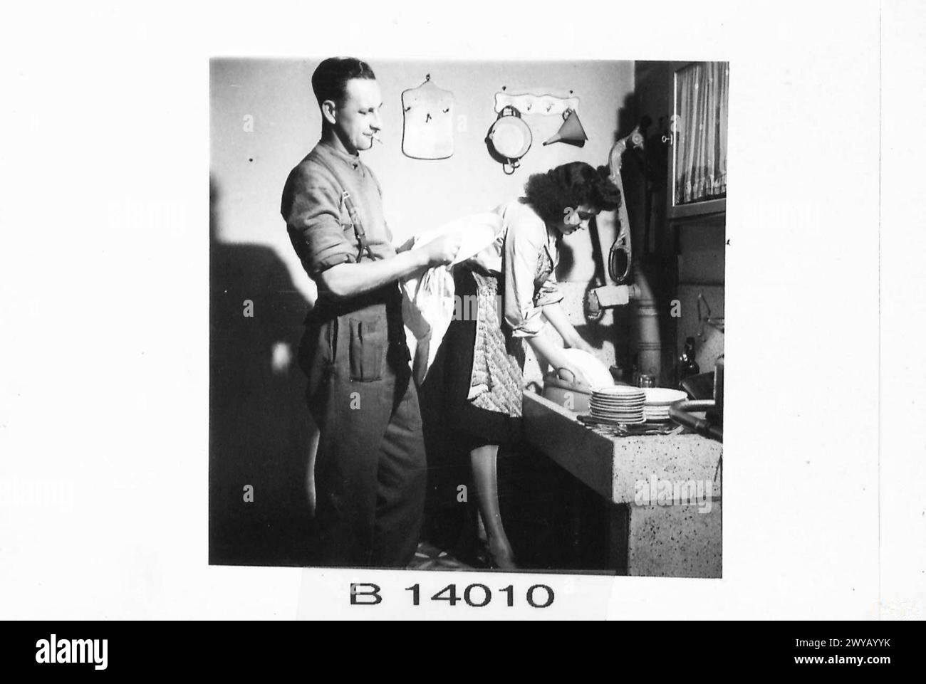 A British soldier assists Anne, a civilian, with the after-dinner wash ...