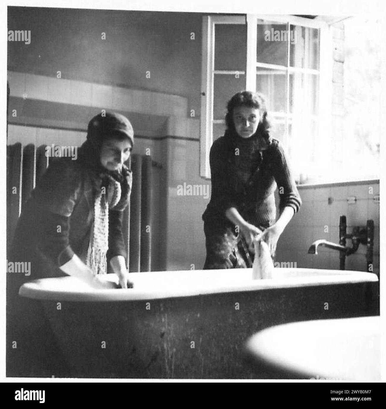 German civilian women are performing laundry in communal baths under ...