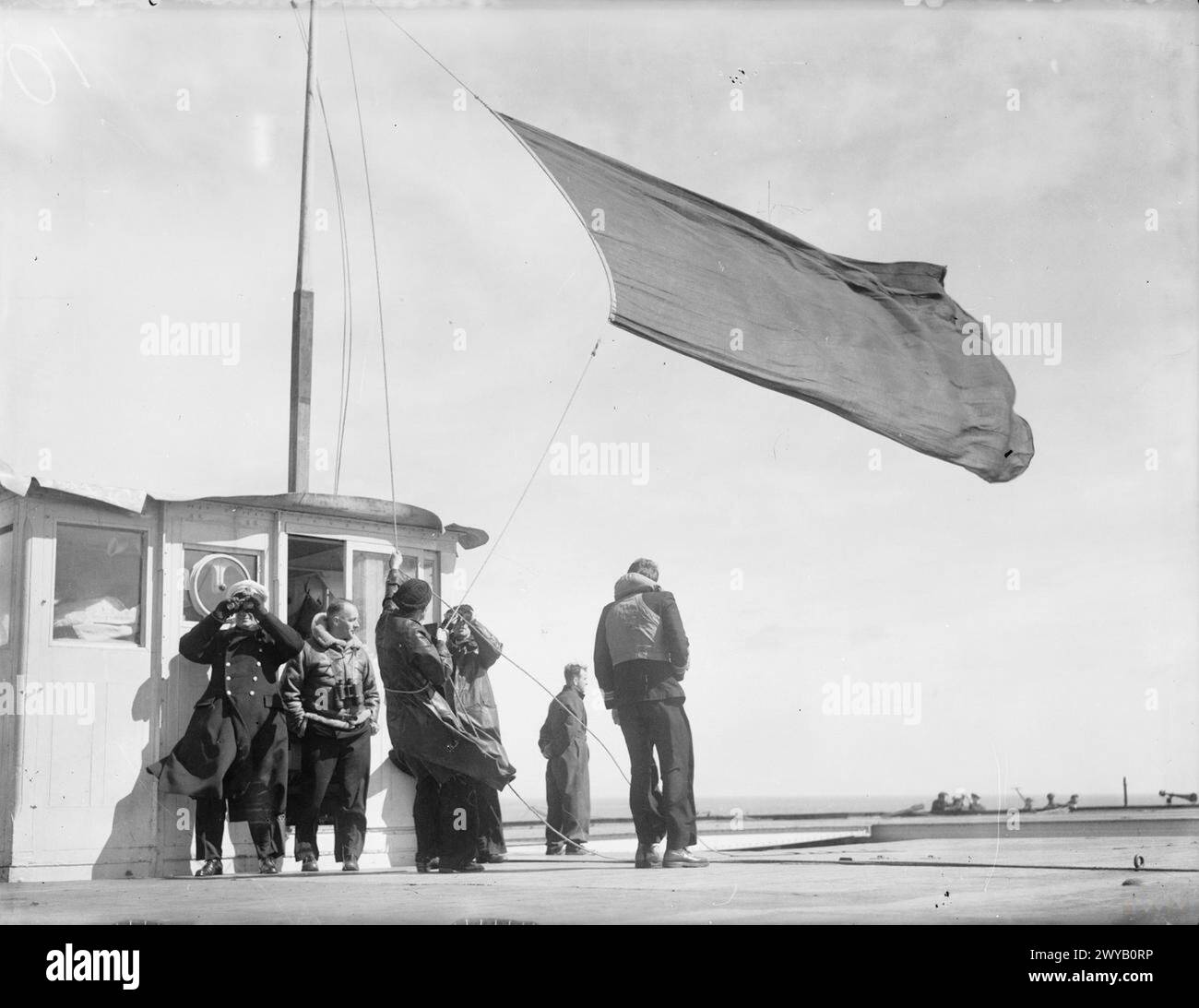 Captain G. T. Phillips, Commander of HMS Argus, observes for enemy ...