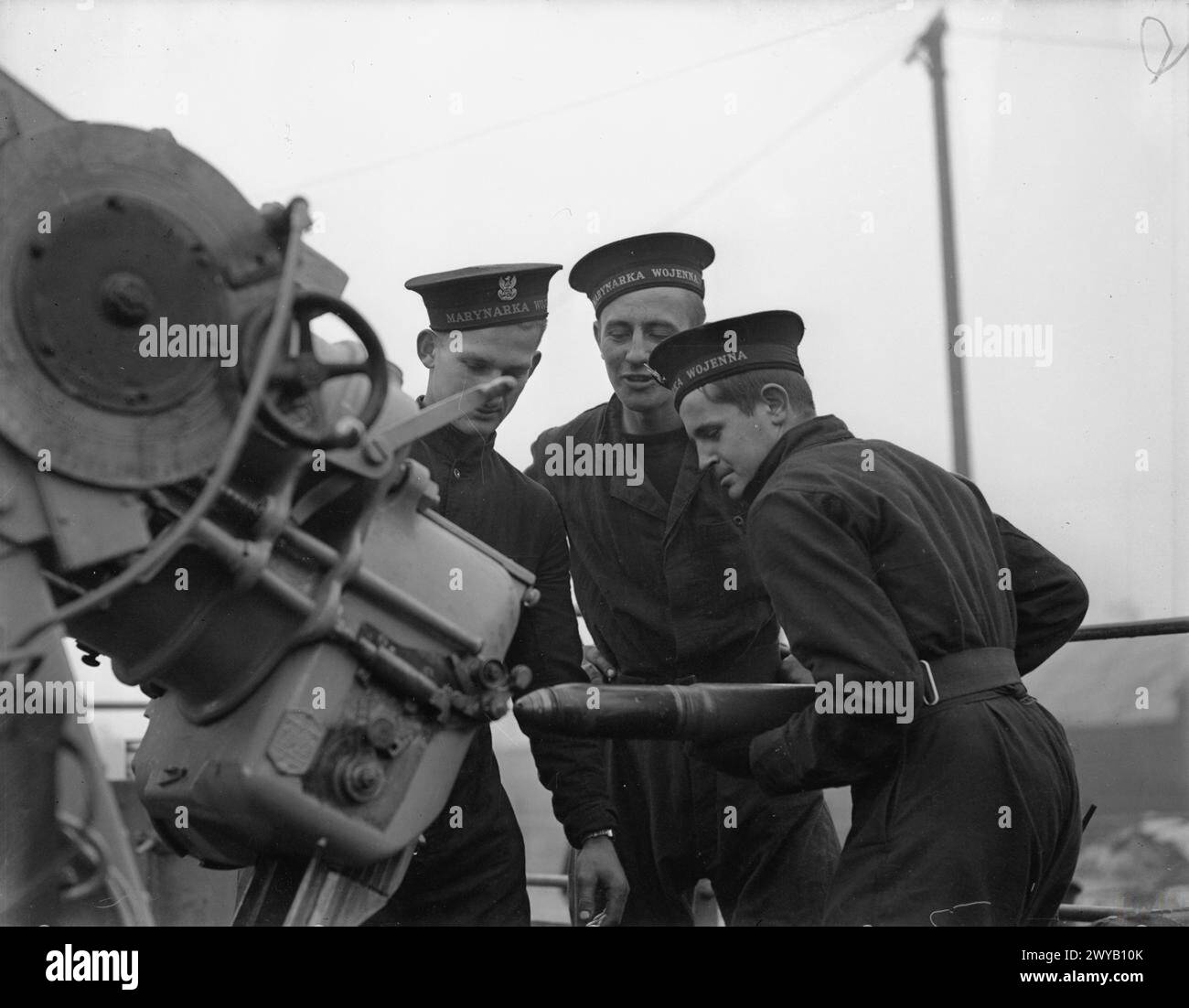 Three sailors from Brazil, USA, and Canada operate a 3-inch anti ...