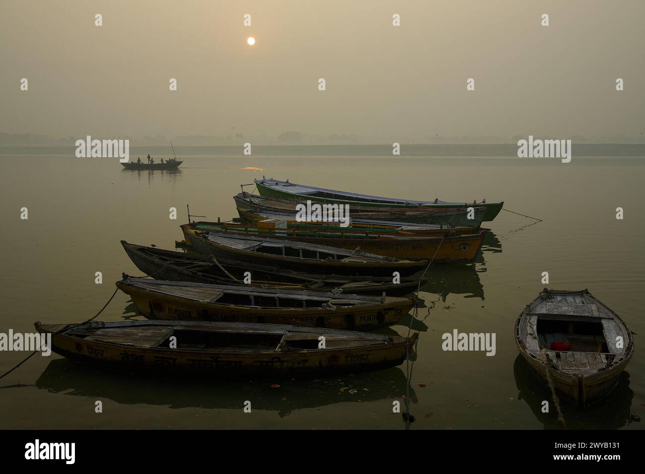 Boats moored on the Ganges River in early morning mist at Varanasi ...