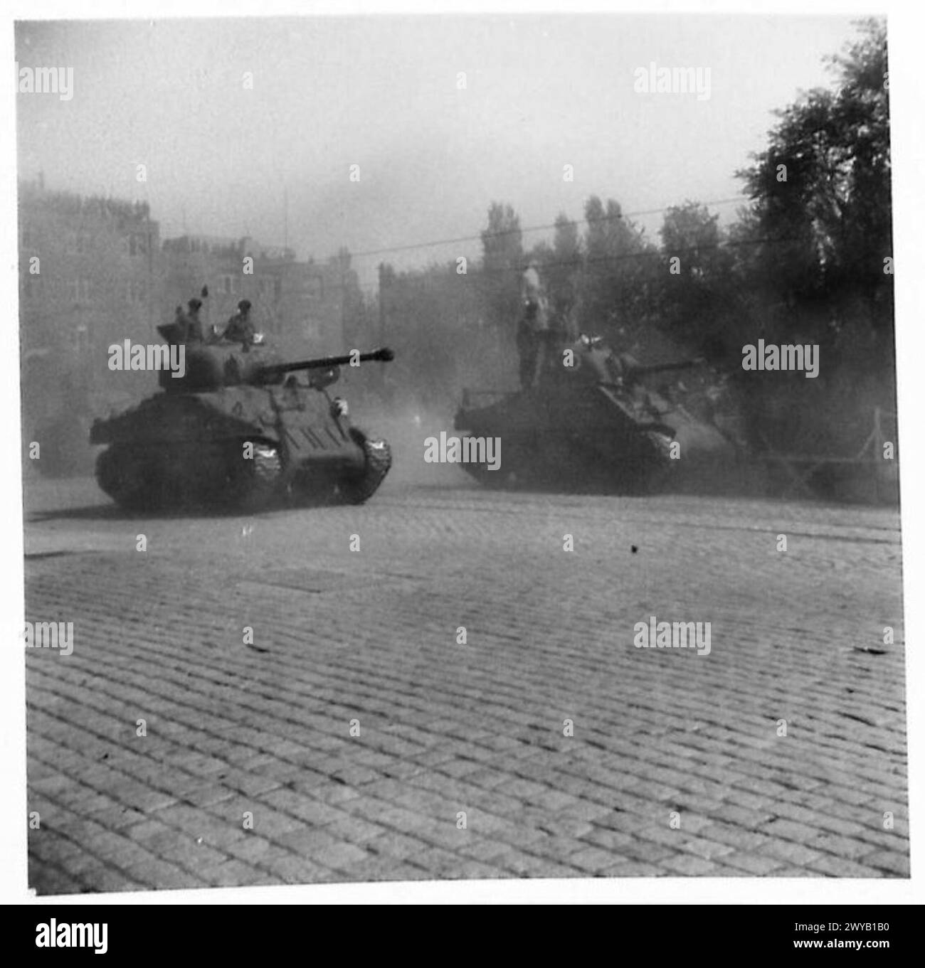 Armoured vehicles, tanks, and artillery pass a saluting base during the ...