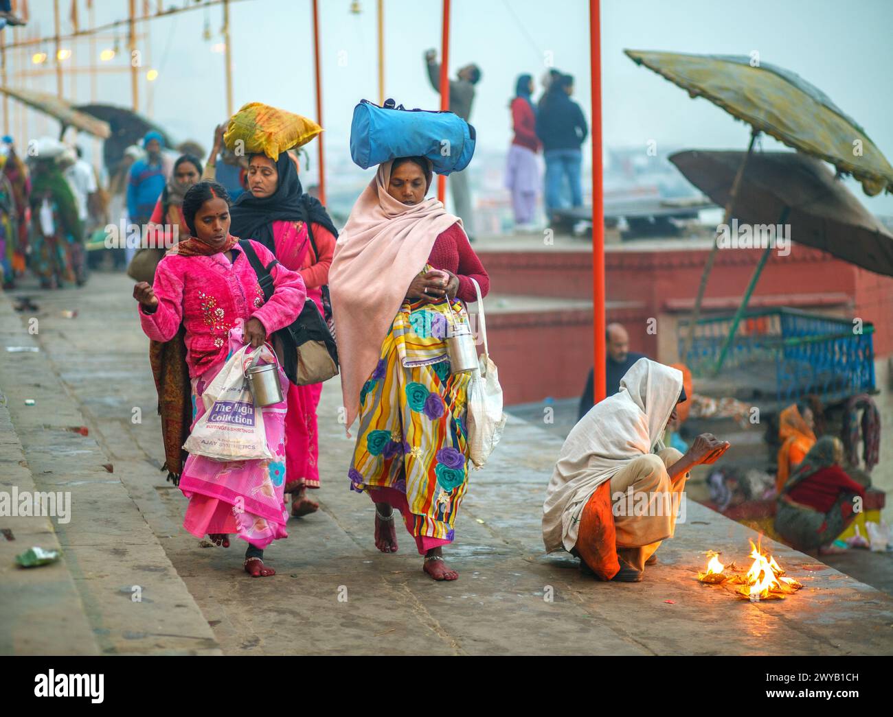 Pilgrims walking alongside the Ganges River at Dashashwamedh Ghat in ...