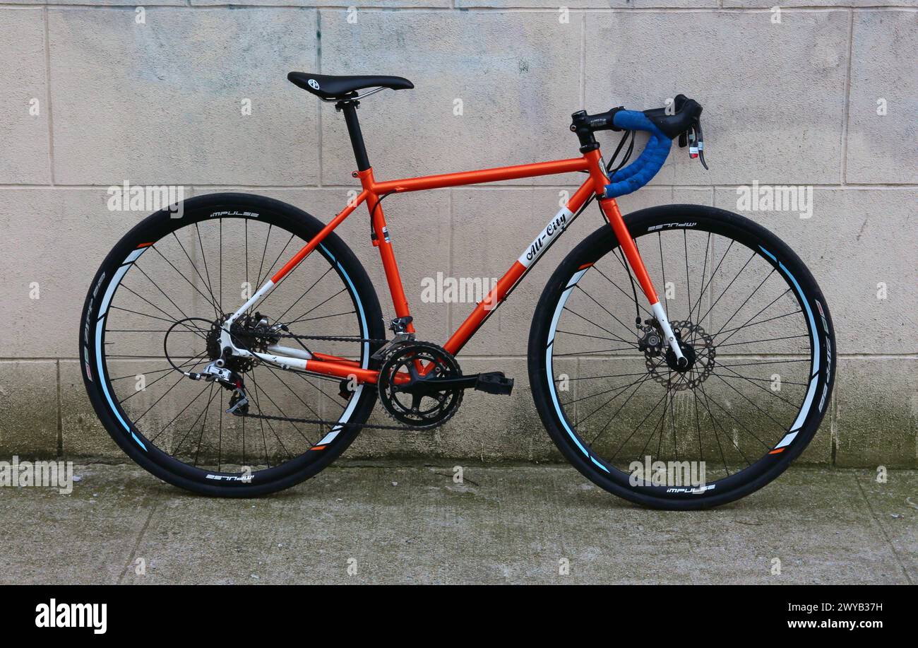 All City Macho Man gravel cyclocross bike in orange leaning against a ...