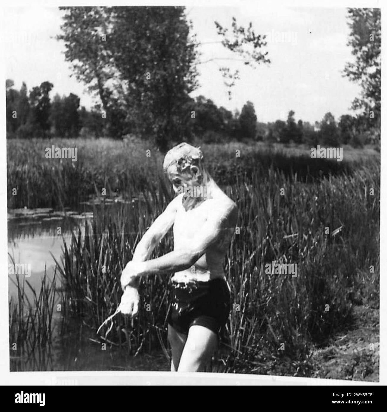 Gunner Ernest Swatton of Oxford bathes in the river Aure near Bayeux ...