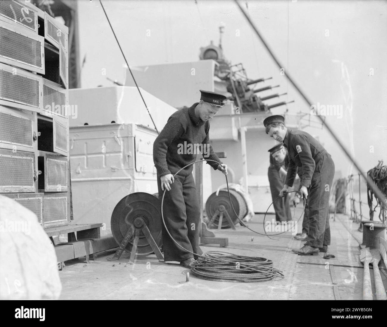 Able Seaman Joe W 'Ginger' Scotcher is coiling an electric cable aboard ...
