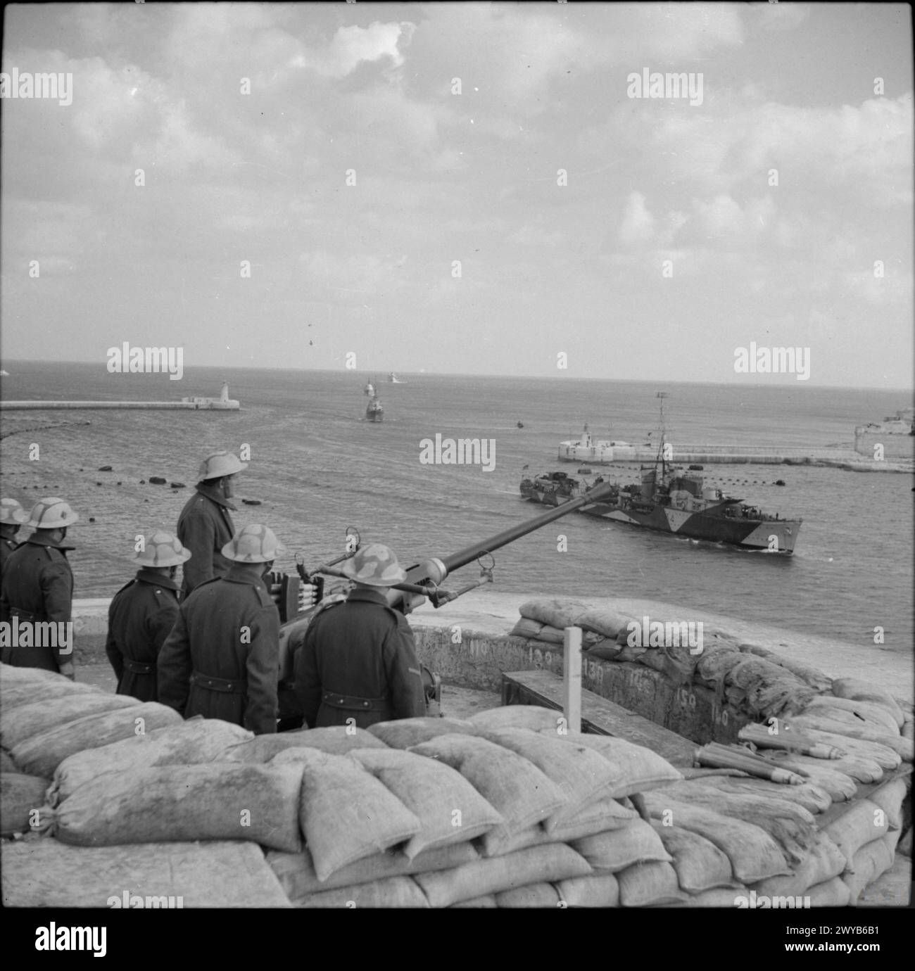 A 40mm Bofors anti-aircraft gun and its British Army crew monitor the ...
