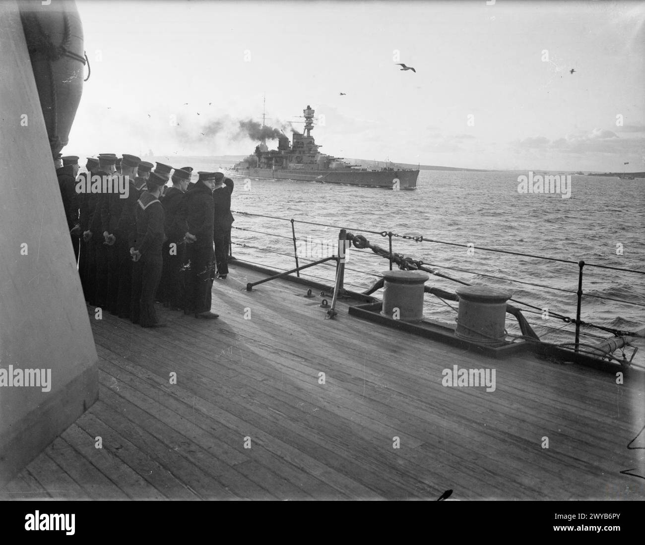 Men line the deck of the battlecruiser HMS Rodney as it departs from ...