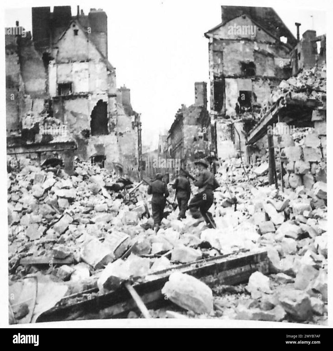 A British patrol moves through a ruined street in Caen during ...