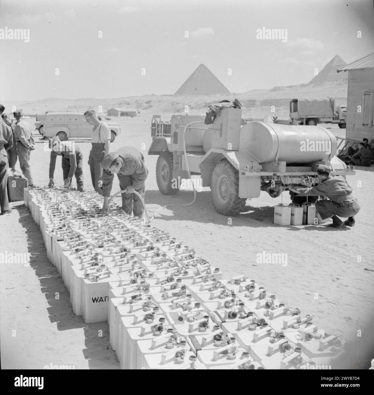 British Army personnel filling water tins from a bowser near the ...