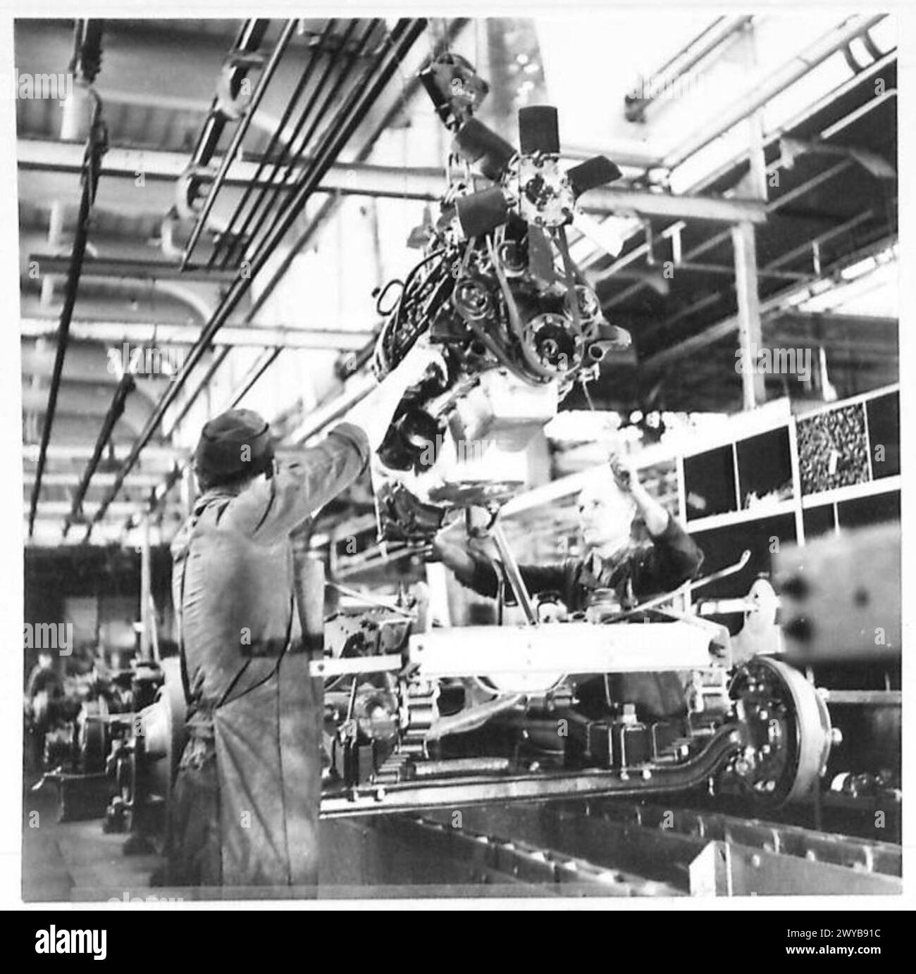 FORD WORKS AT COLOGNE - Original wartime caption: Engine is swung over ...