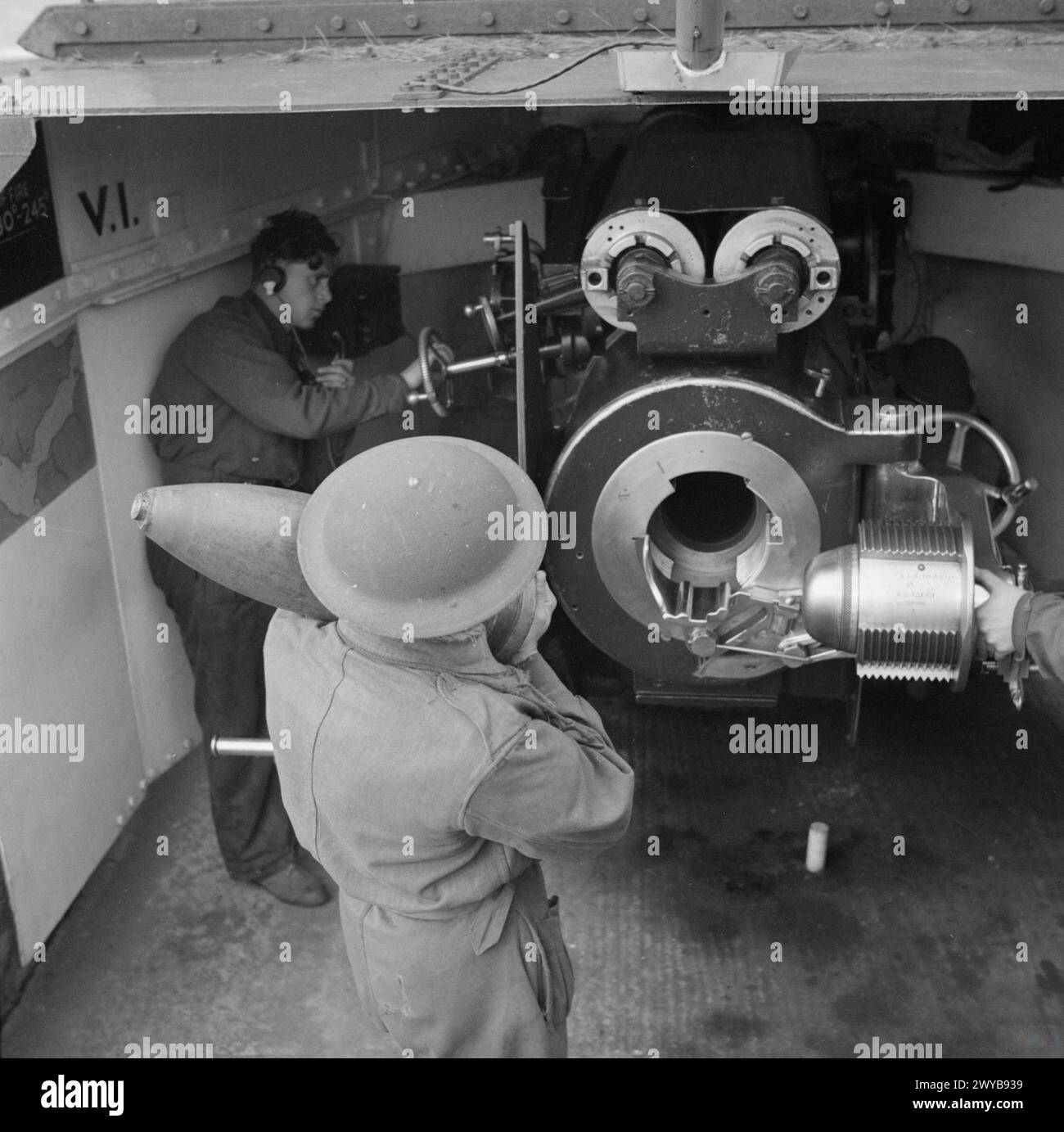 A shell is prepared for loading in a British coastal battery behind ...
