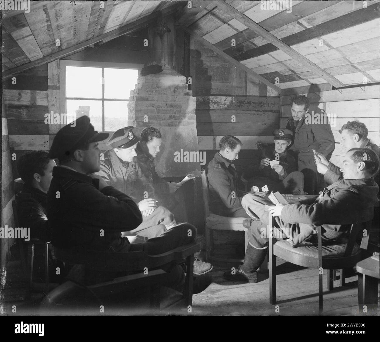 Pilots of No. 56 Squadron RAF relaxed in their dispersal hut at B80/Volkel, Holland, between ...