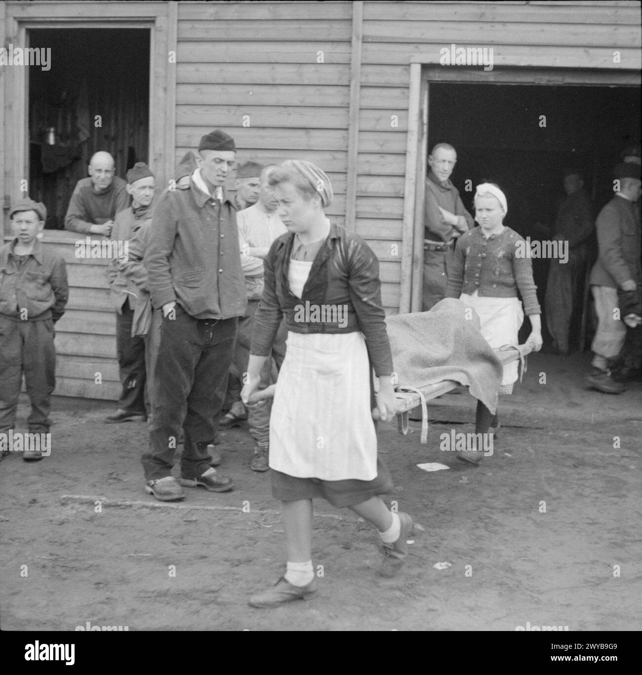 German women carry a typhus patient on a stretcher to a waiting ...