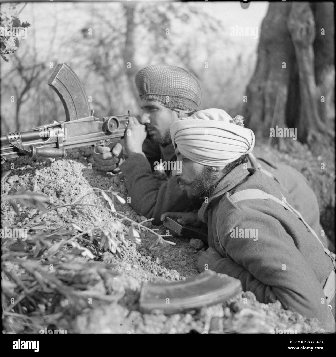 Sikh soldiers of the British Army operate a Bren gun in the line near ...