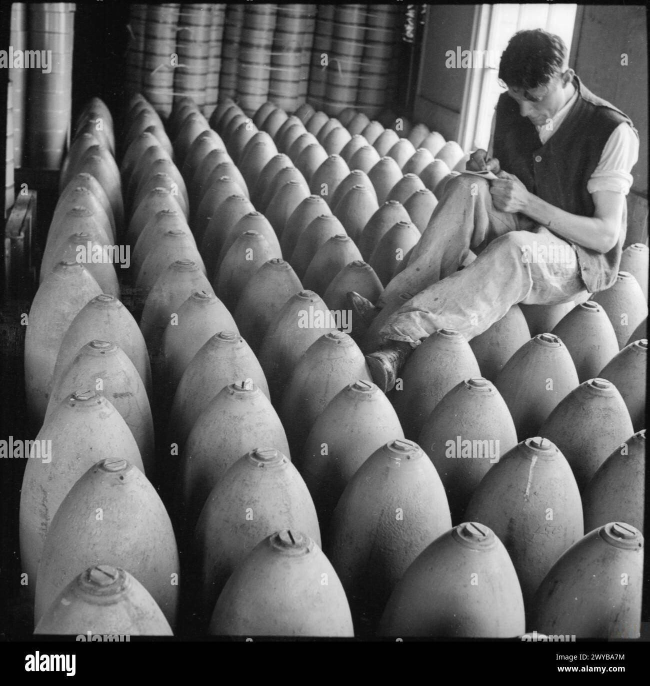 MUNITIONS PRODUCTION IN BRITAIN, 1940 - Rows of heavy bombs are checked ...