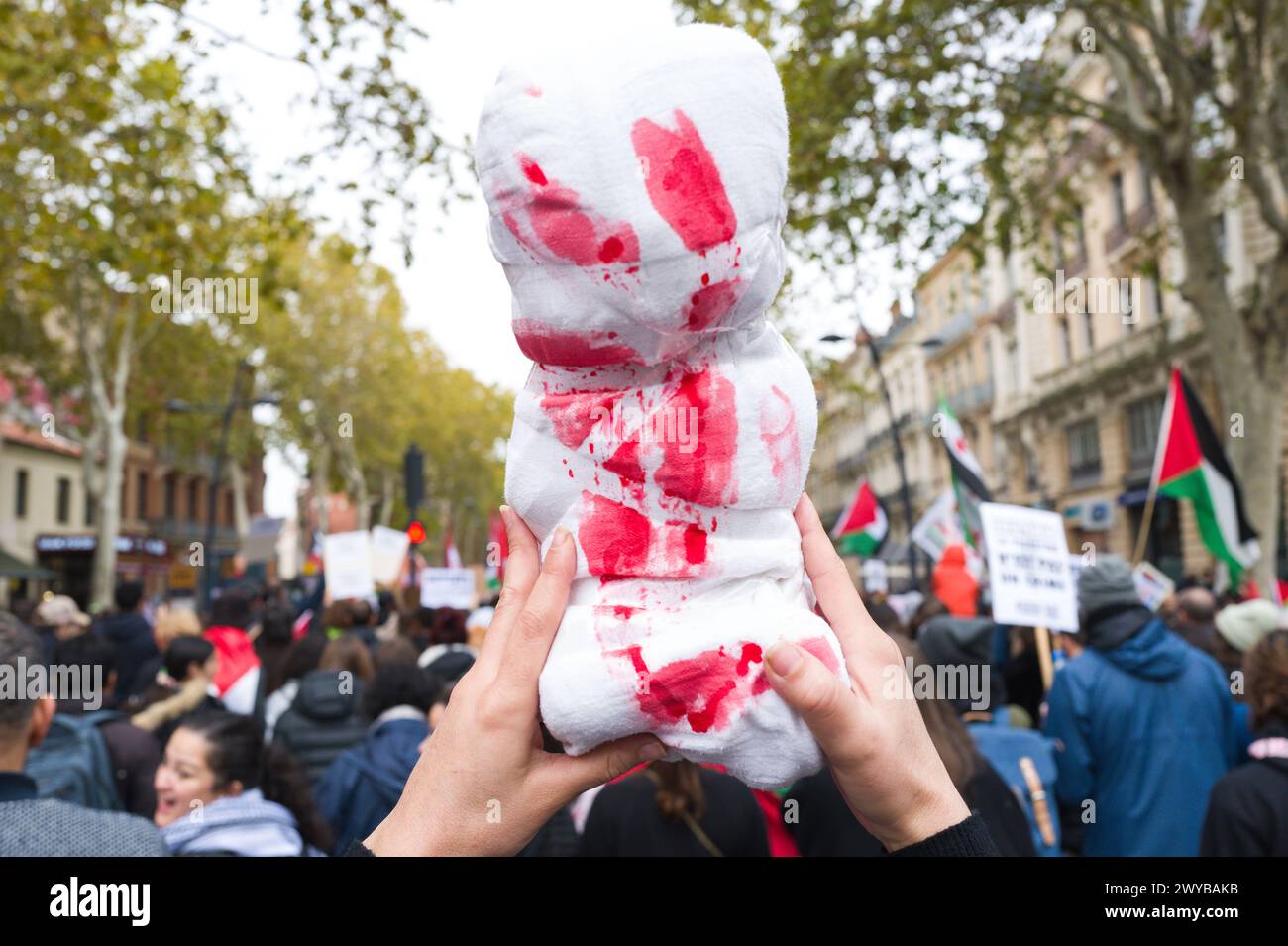A woman holds at arm s length a shroud stained red, representing a dead ...