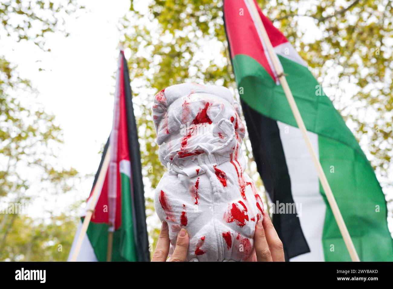 A woman holds at arm s length a shroud stained red, representing a dead ...
