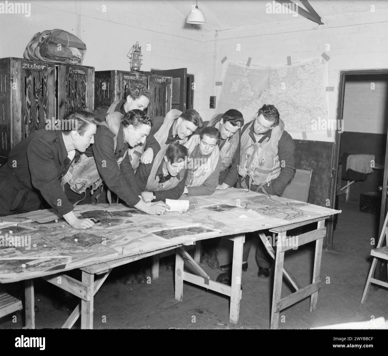 Pilots of No. 602 Squadron RAF study target maps and photographs in the ...