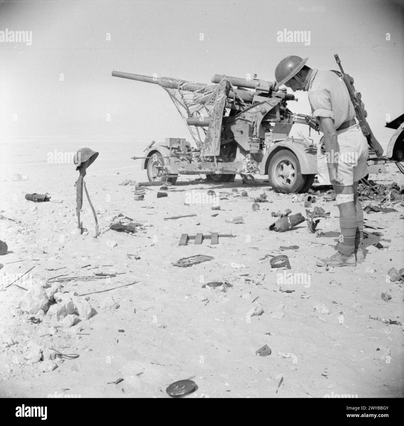 A British soldier inspects a German 88mm gun reportedly disabled by RAF ...