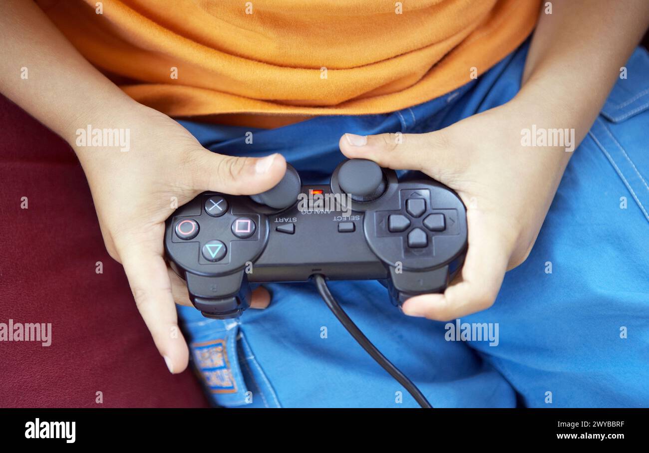 8 year old playing with videogame console Stock Photo - Alamy
