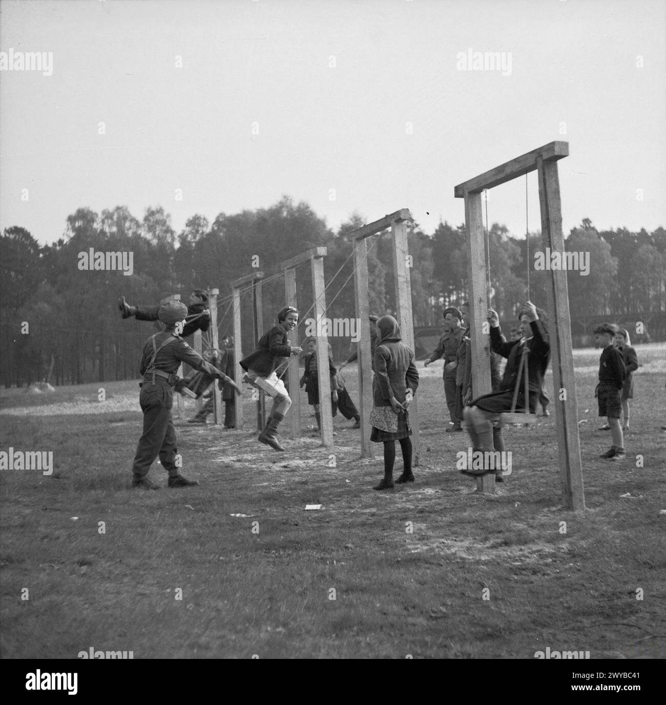 In April 1945, children at Bergen-Belsen’s Camp No 2 play on swings ...