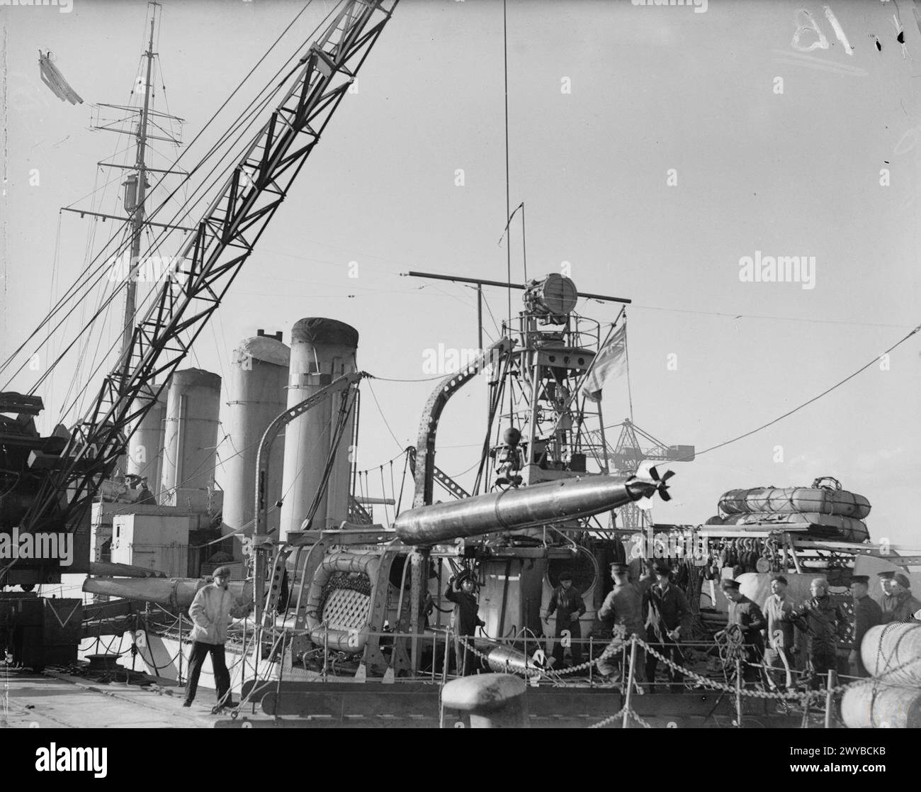 Crew loading and adjusting torpedoes aboard an ex-American destroyer at ...