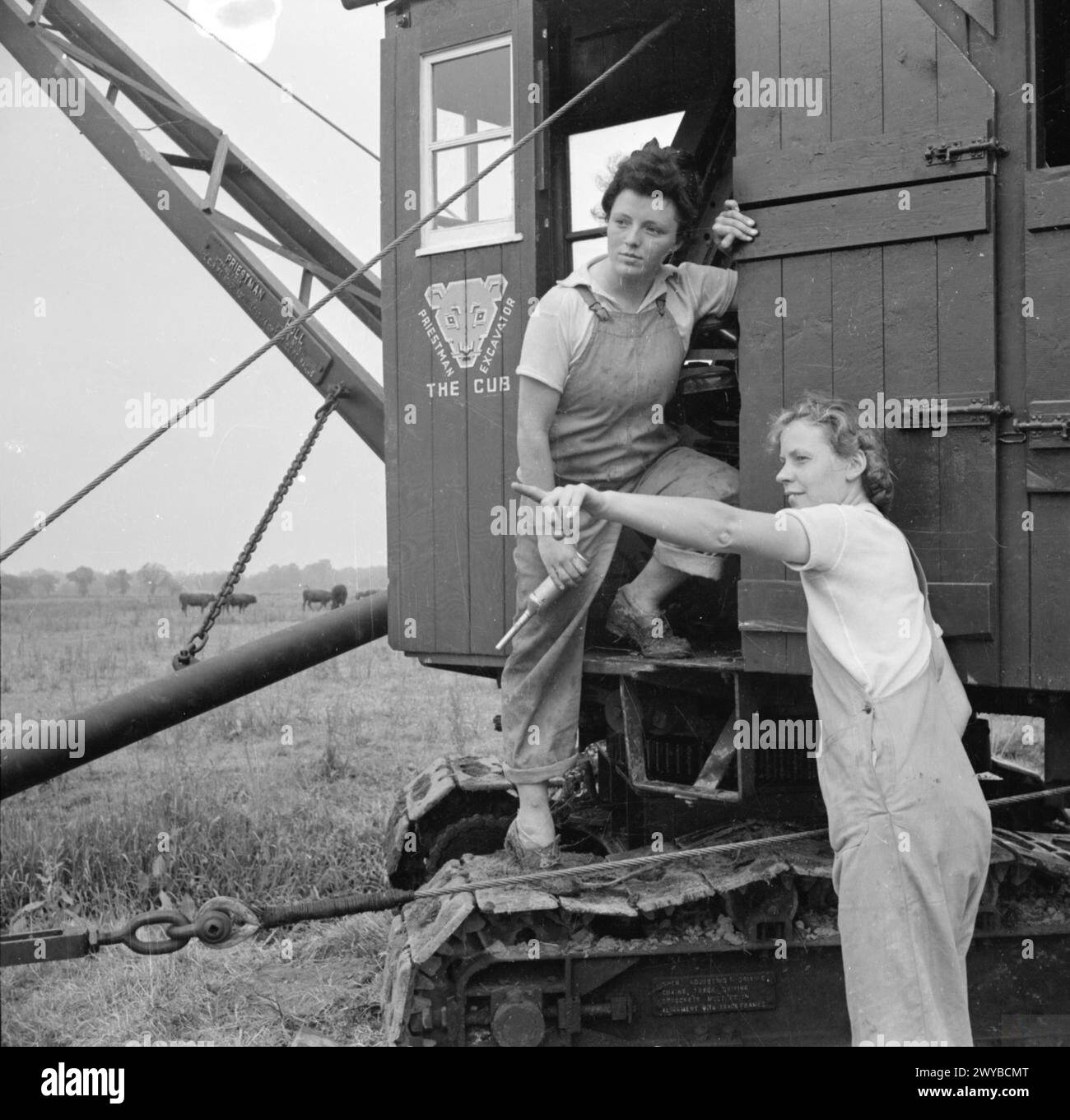 Two Land Girls operate a drag-line excavator at Clyst Marshes, Devon ...