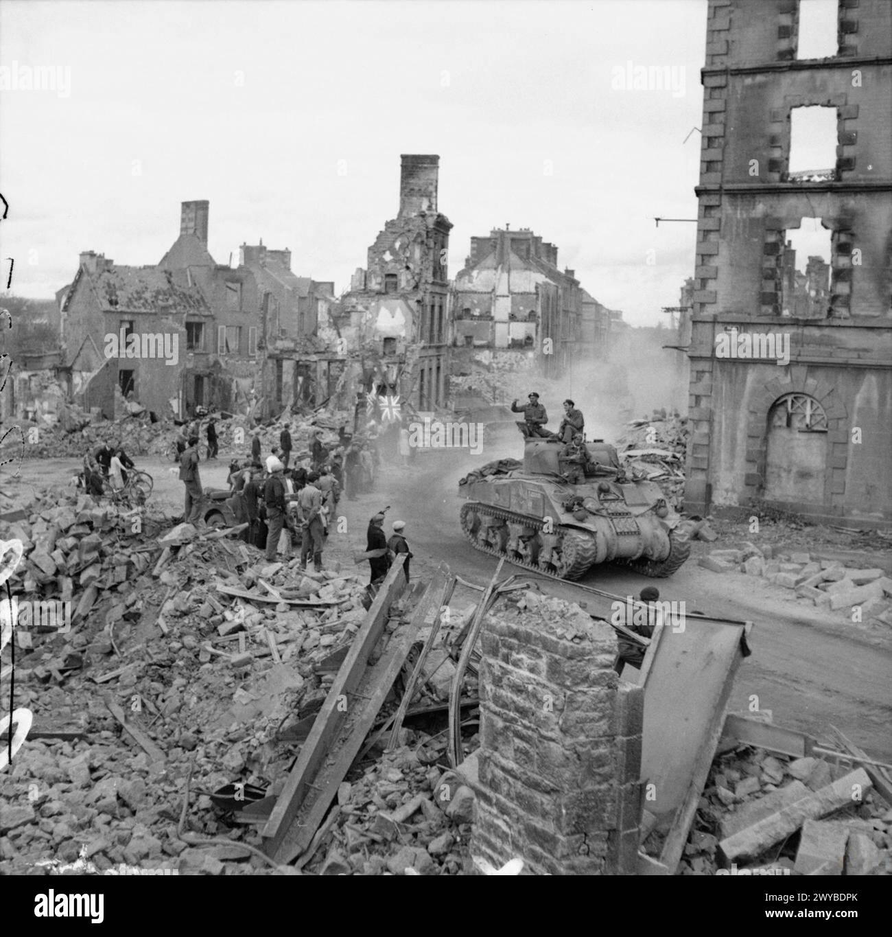 THE BRITISH ARMY IN NORMANDY 1944 - A Sherman tank drives through the ...