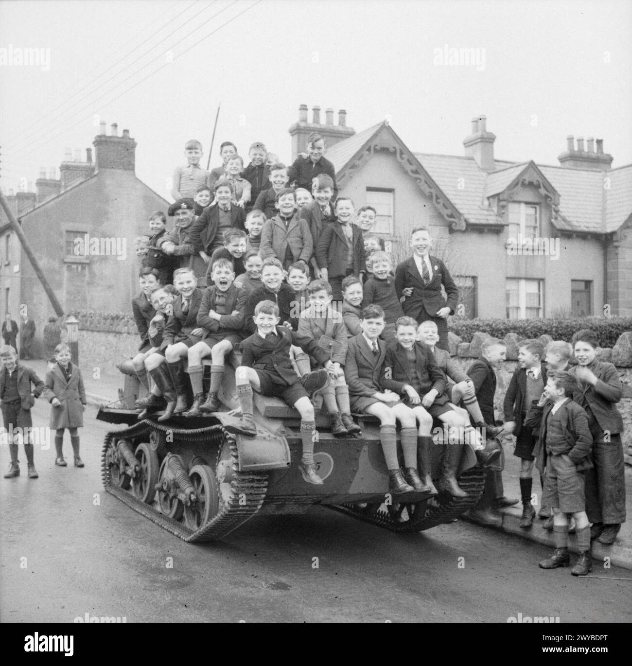 Small boys are pictured covering a Light Tank Mk VI of the 2nd Fife and ...