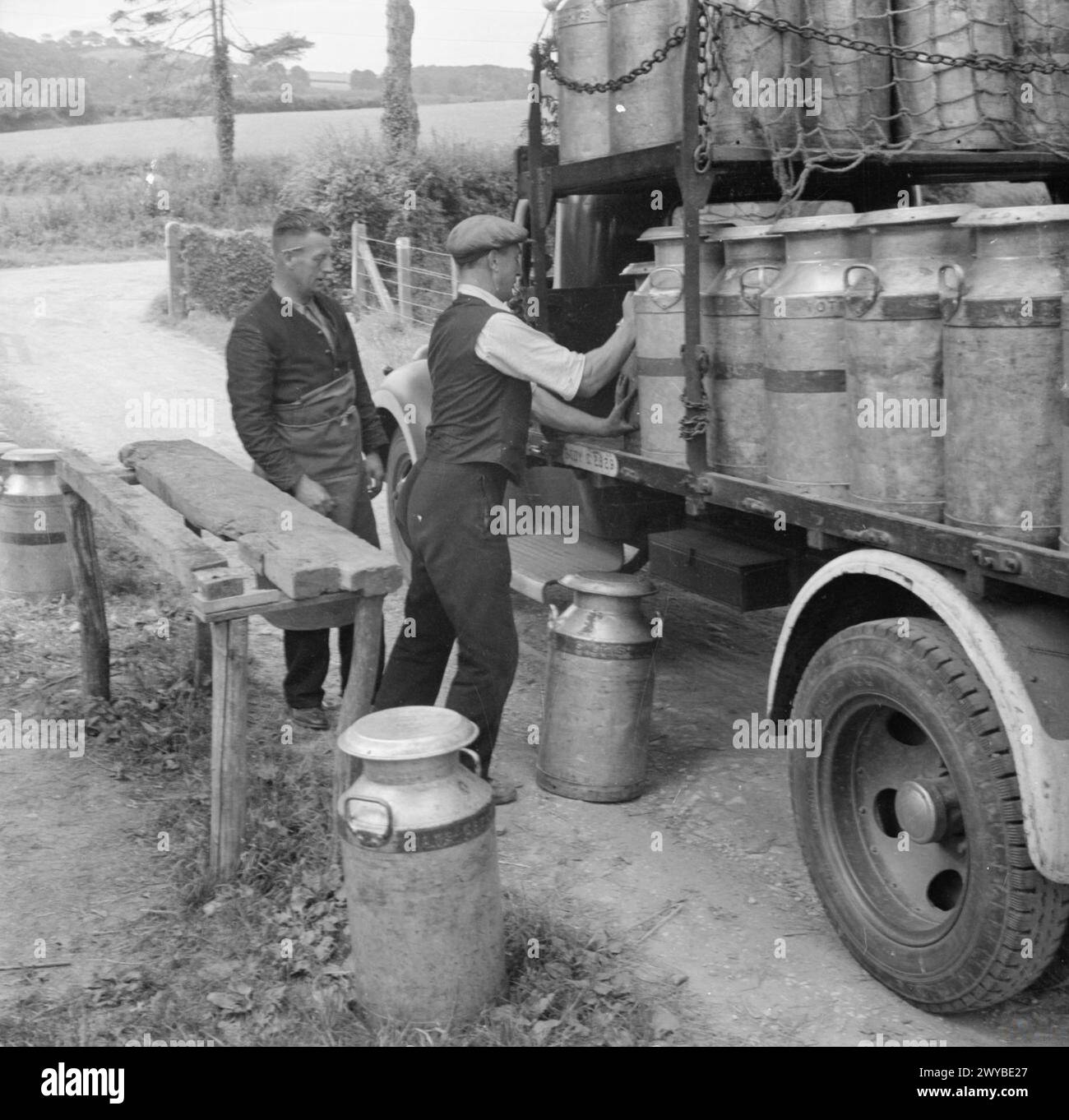 A farmer at Mount Barton Farm in Devon, England, loads milk churns onto ...