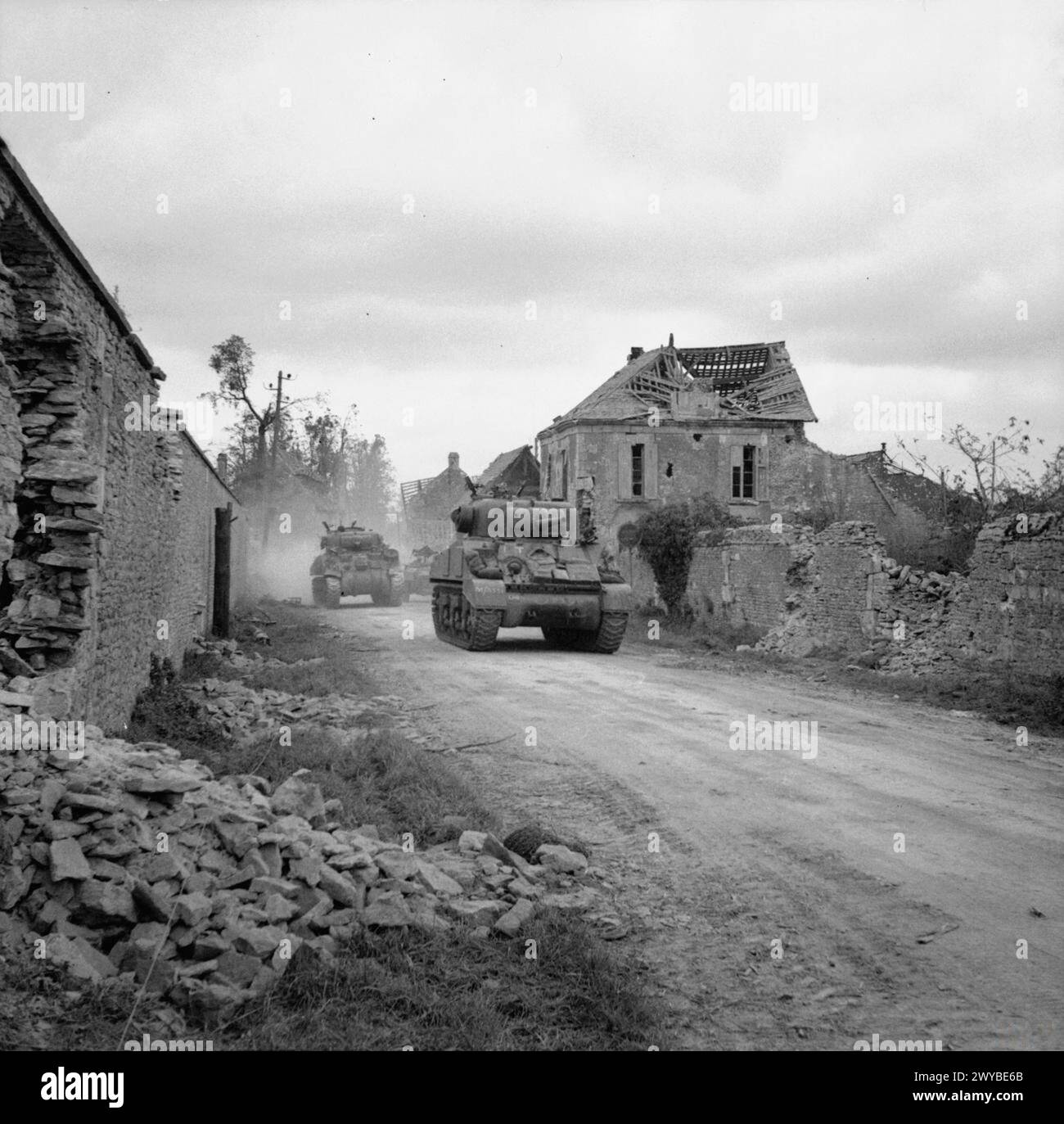 THE BRITISH ARMY IN NORMANDY 1944 - Sherman tanks move through Lebisey ...