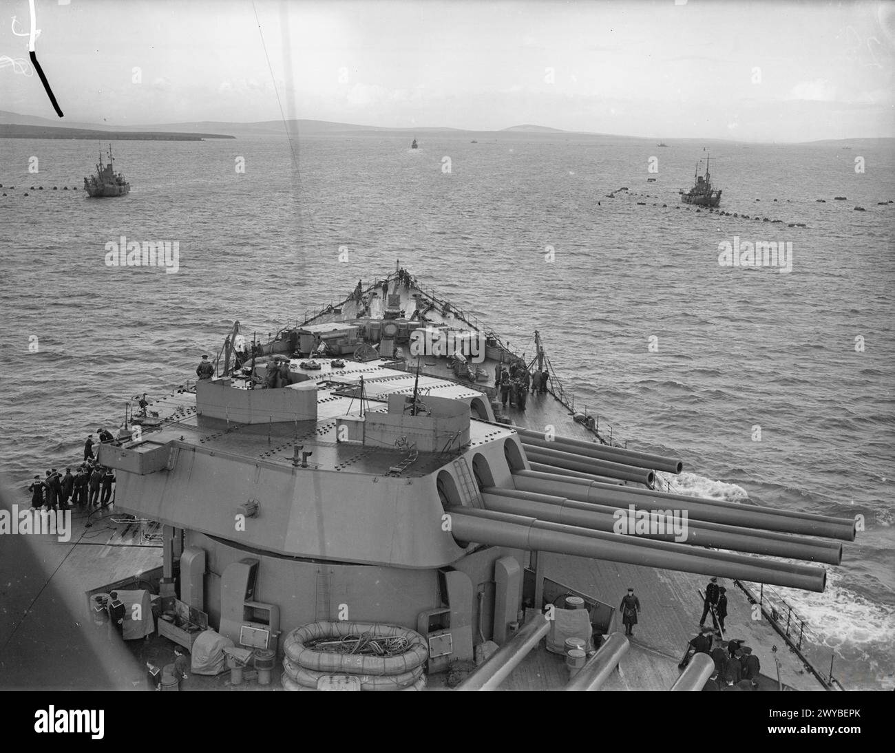 In 1940, HMS Rodney, a battleship, is at sea entering a harbour while ...