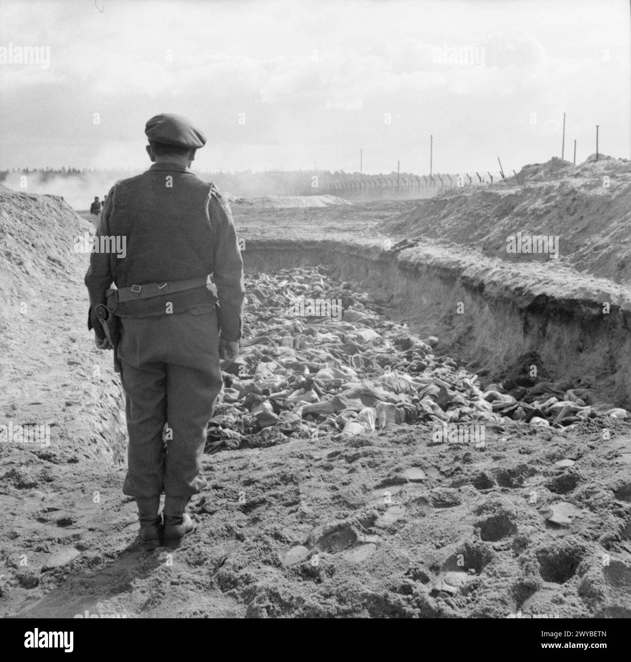 A British Army chaplain conducts a religious service over a mass grave ...