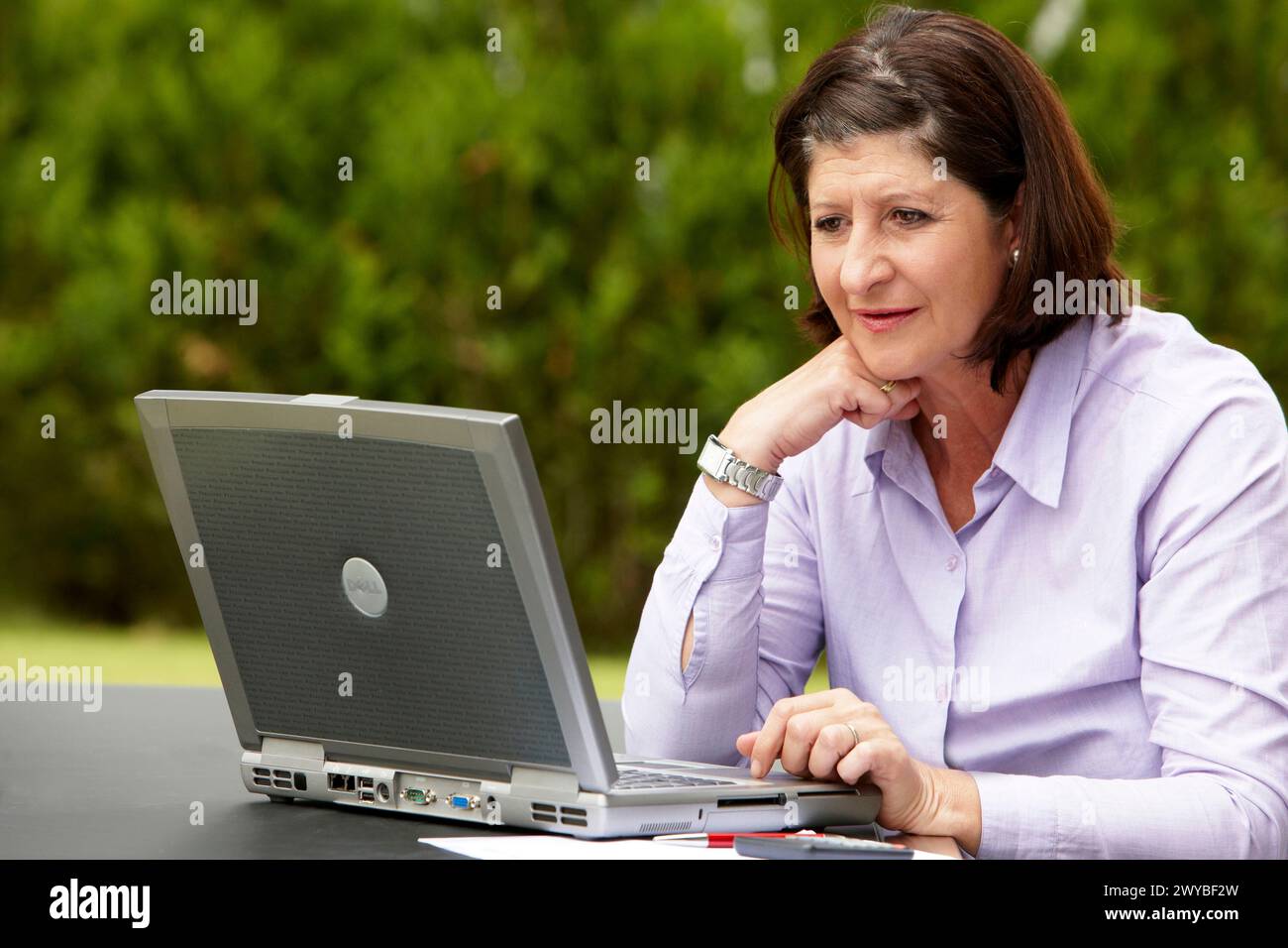 Retired woman using laptop computer in her garden Stock Photo - Alamy