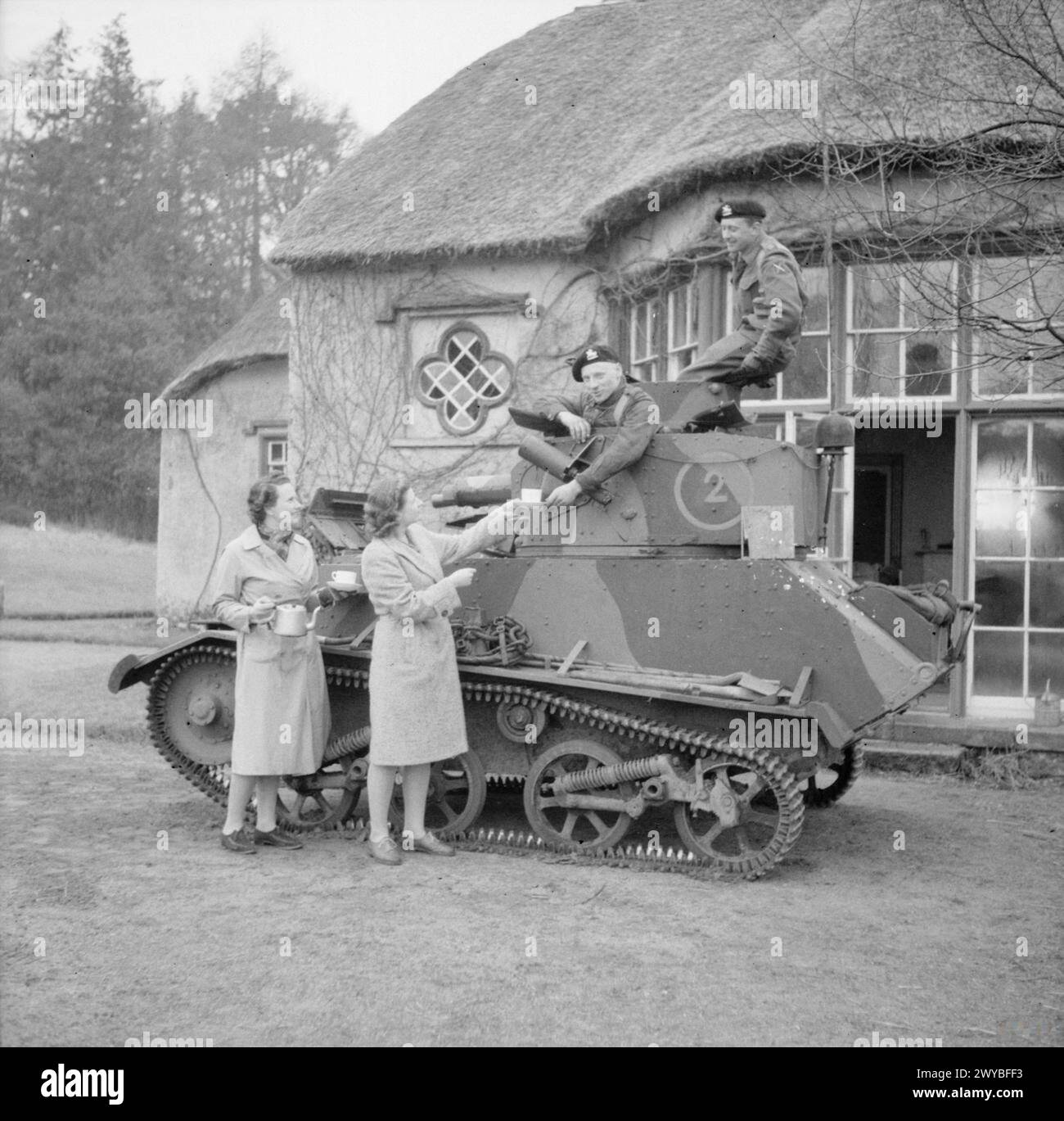 Women serve tea to the crew of a Light Tank Mk VI of 'C' Squadron, 2nd ...