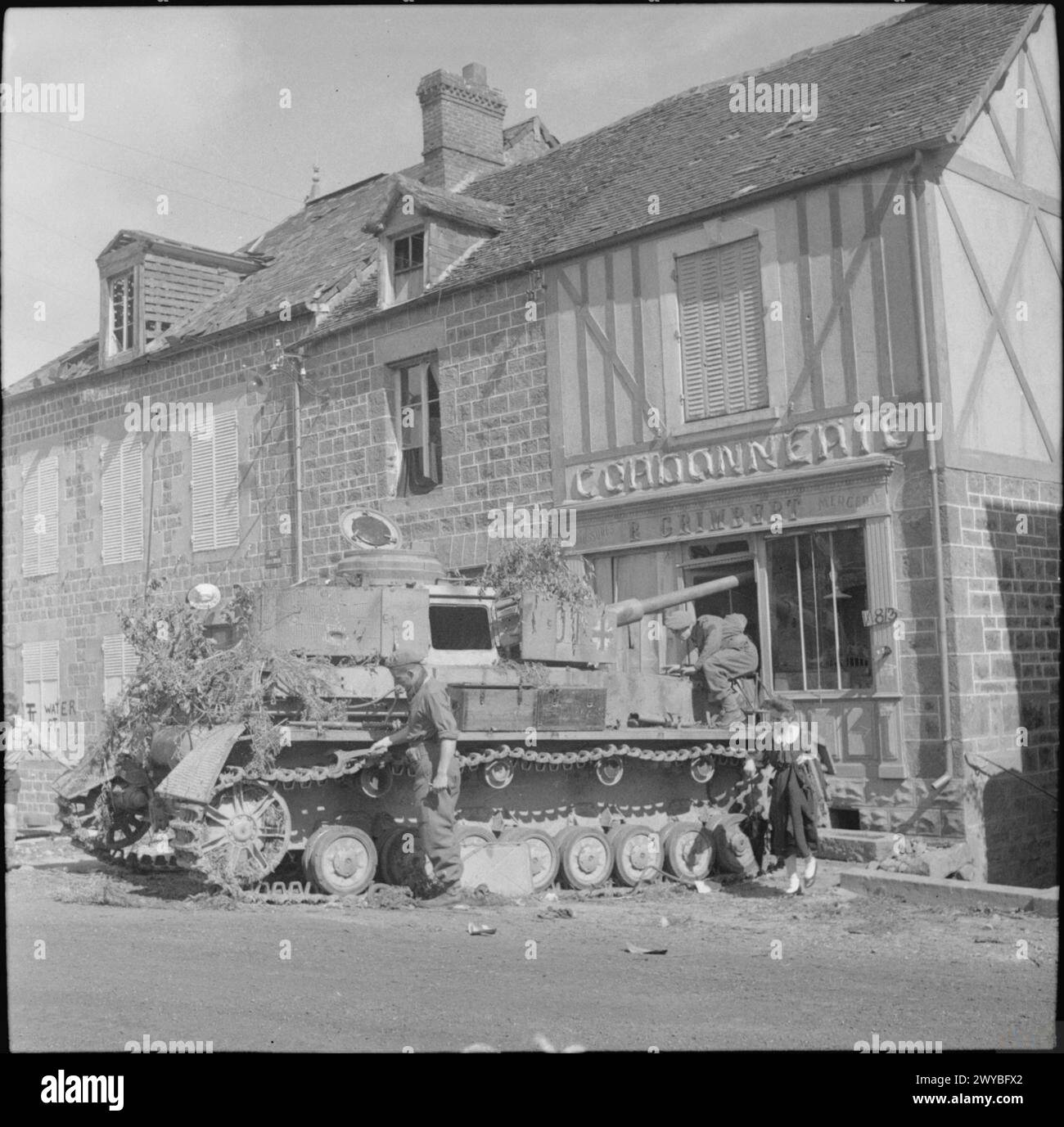 British troops and a civilian inspect an abandoned German Mk IV tank ...