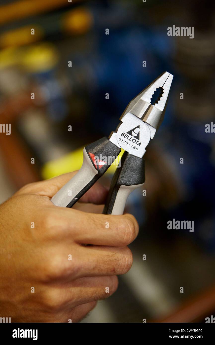 Hand holding pliers Stock Photo - Alamy