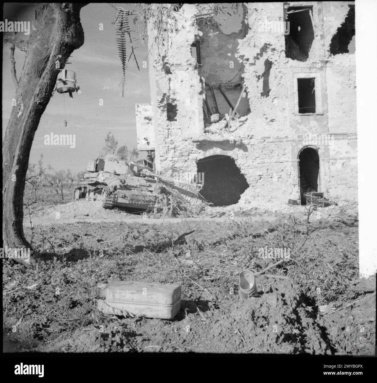A destroyed German PzKpfw IV tank stands beside a wrecked building in ...