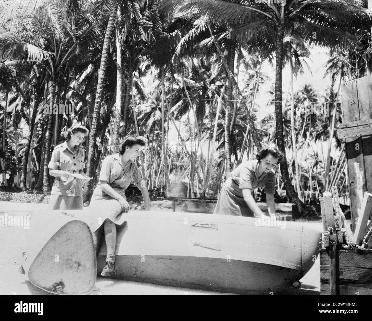 W.A.A.F. equipment assistants handle spare parts for a flying boat at a ...
