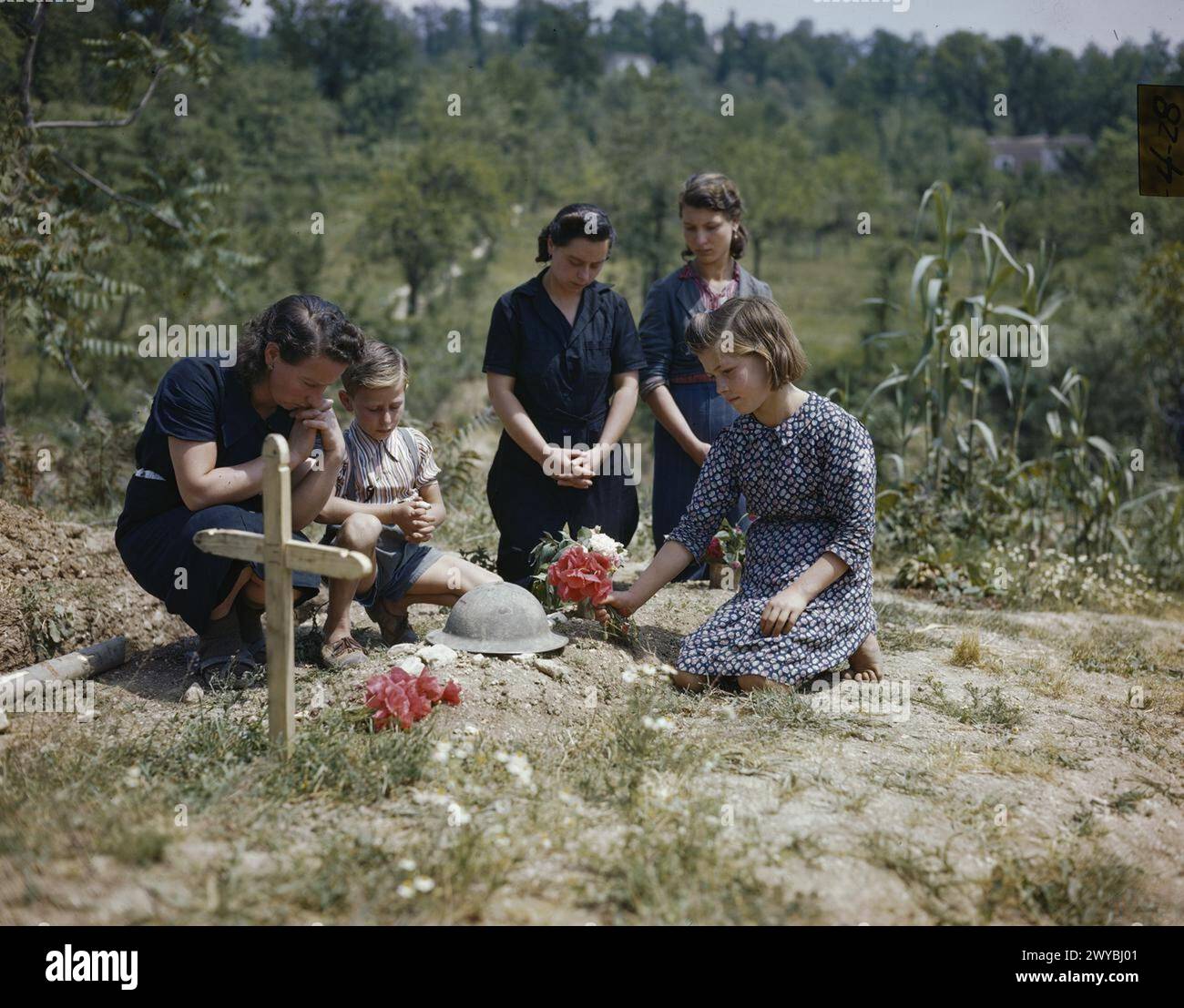 THE WAR IN ITALY, 1944 - A family places flowers on the grave of an ...