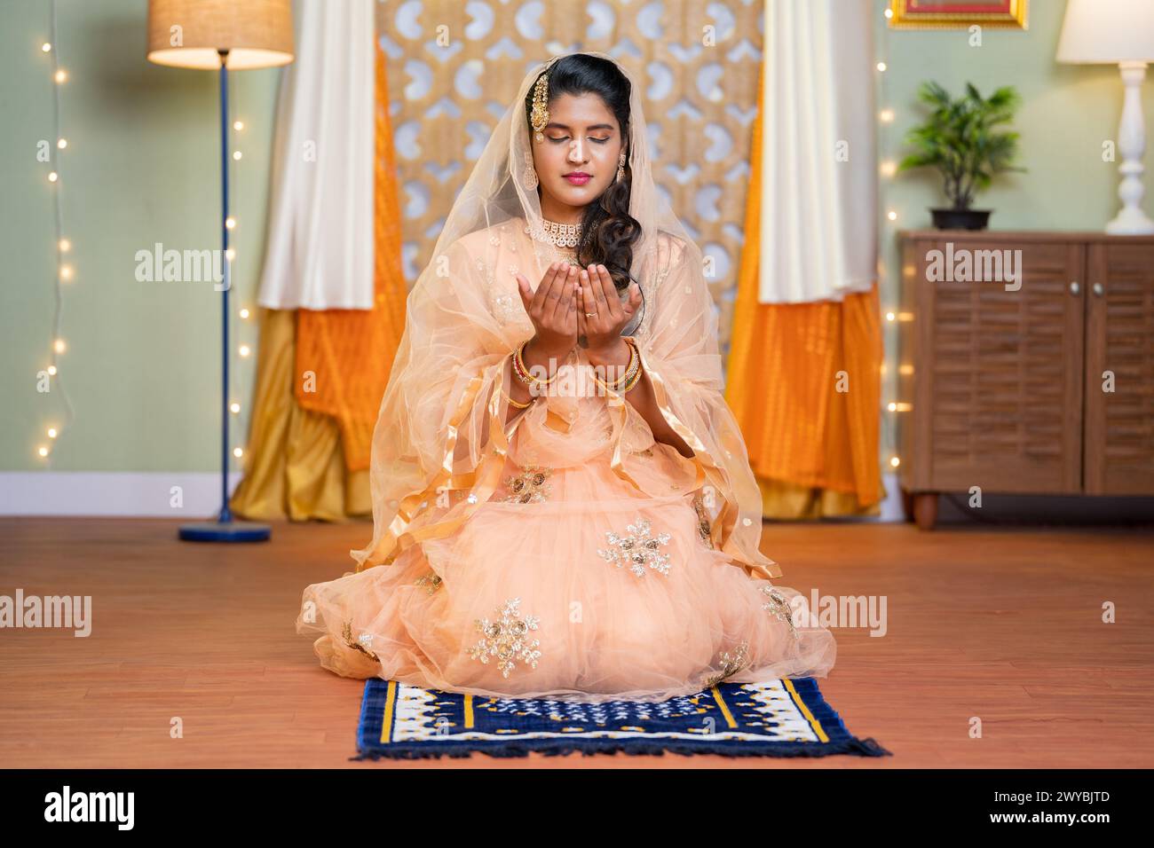 Indian Muslim woman praying or namaz with eyes closed during Ramadan ...