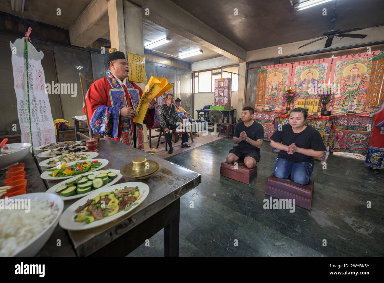 A traditional shaman performing a ritual with offerings to the ...