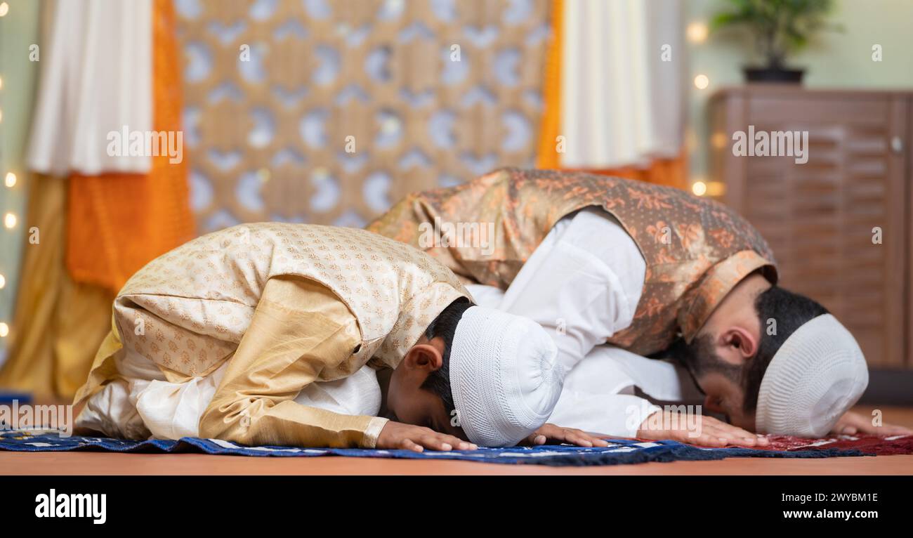 Indian Muslim father with kid doing namaz or praying during ramadan ...