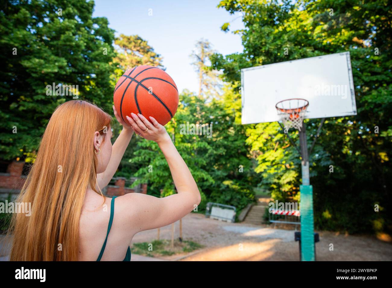 A woman is holding a basketball and shooting, sporty and healthy ...