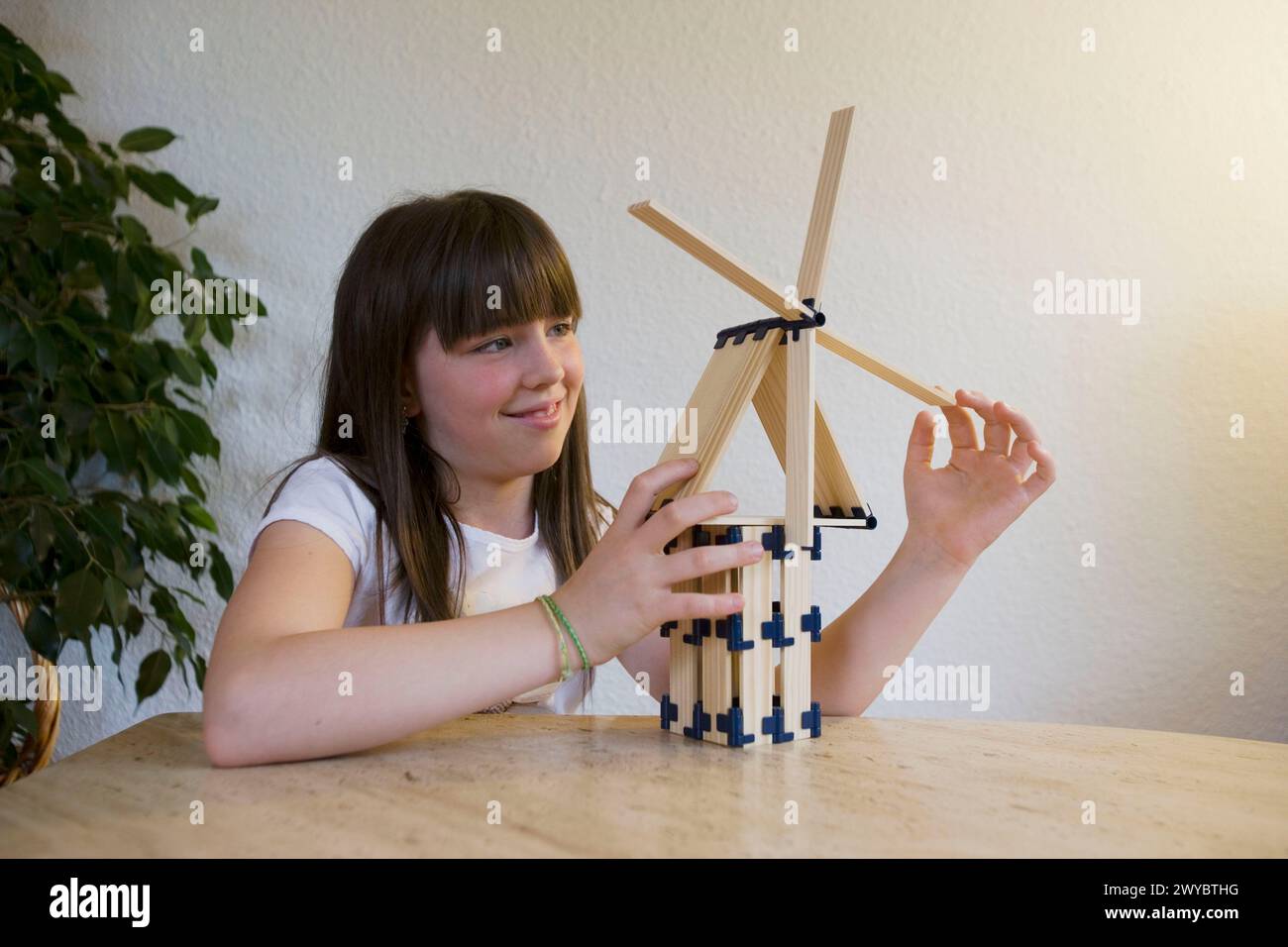 Girl playing with wooden windmill toy Stock Photo - Alamy