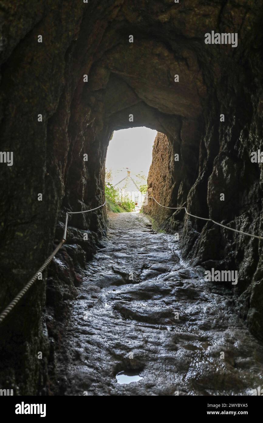 A gap in the rocks or a rock arch or tunnel at Porthgwarra, Cornwall ...